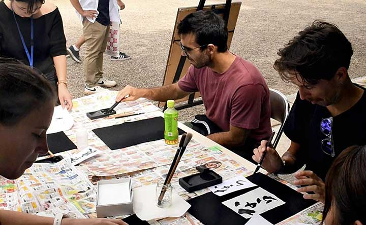 International tourists give calligraphy a try using Nara oil-soot ink ...